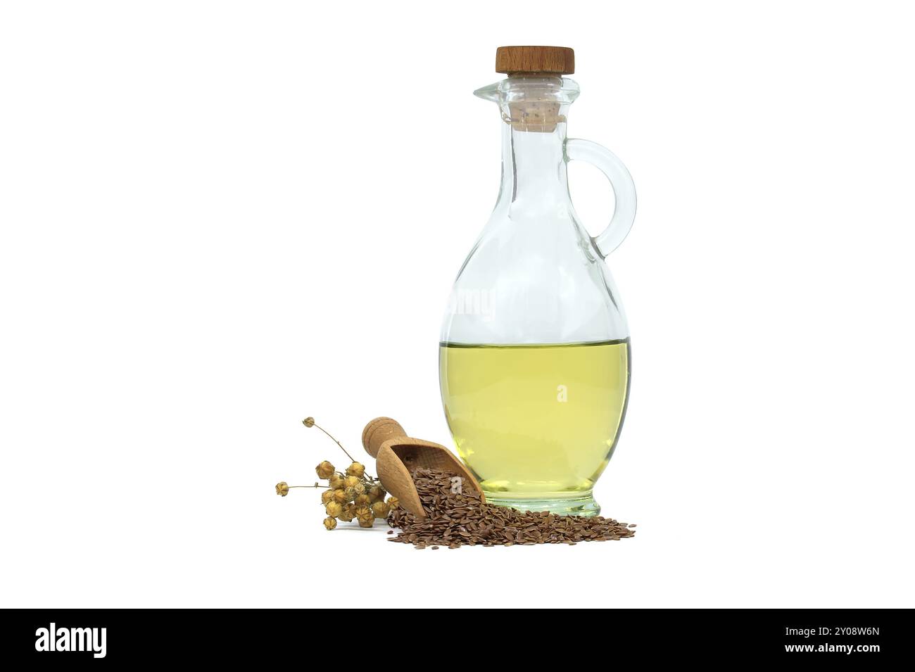 Linseed oil in glass decanter and flax seeds in wooden scoop and bunch of flax plants isolated ...