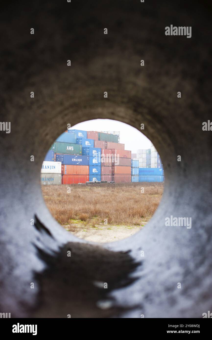View through a pipe onto a stack of containers in the port of Rotterdam ...