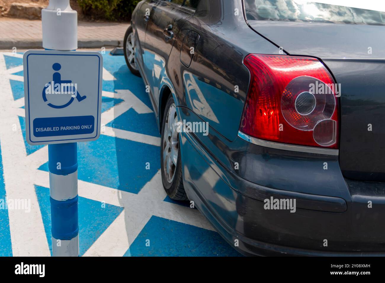 A car parking in a disabled parking spot in the parking lot Stock Photo ...