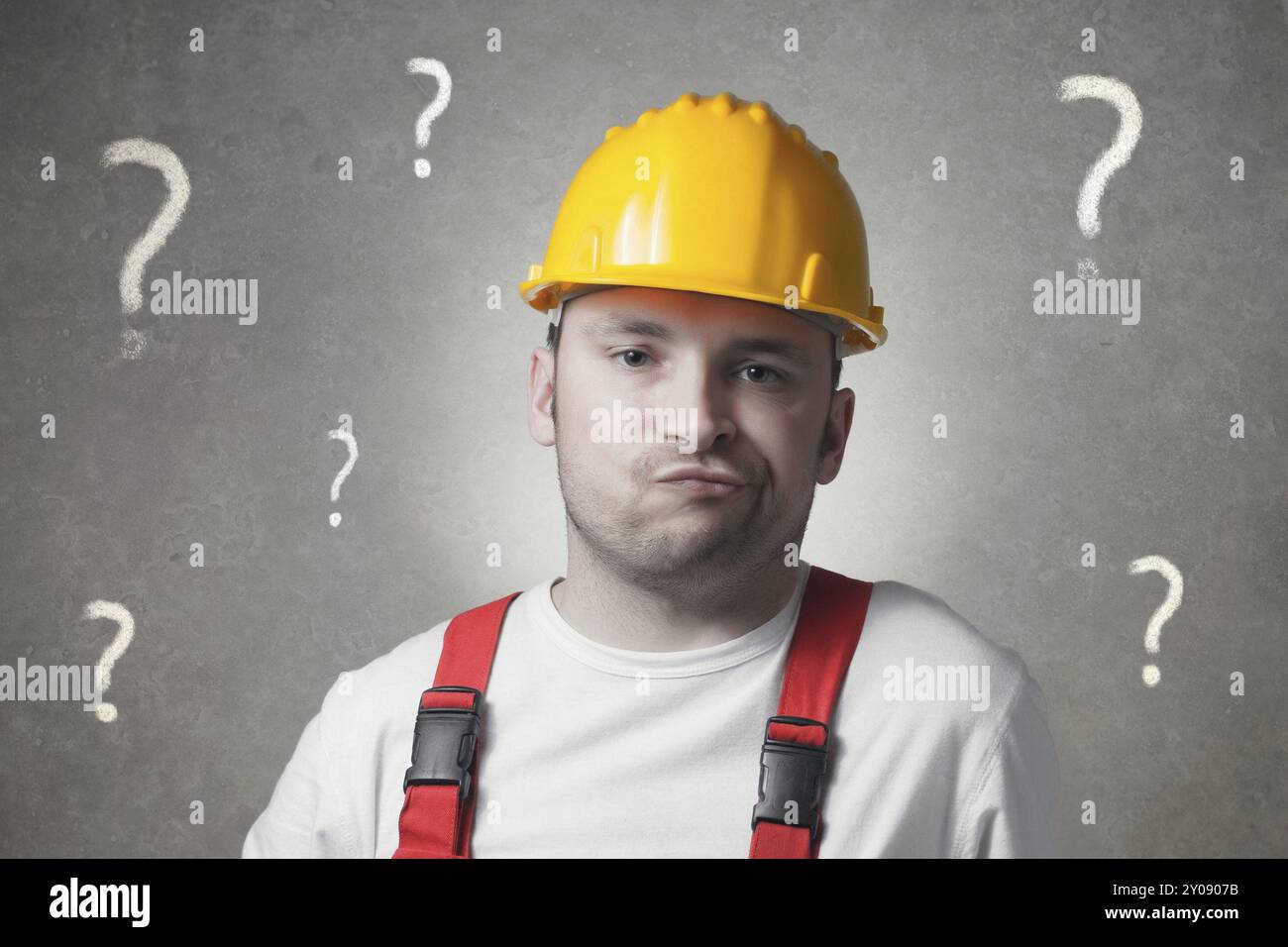 Confused young handyman with question marks Stock Photo - Alamy