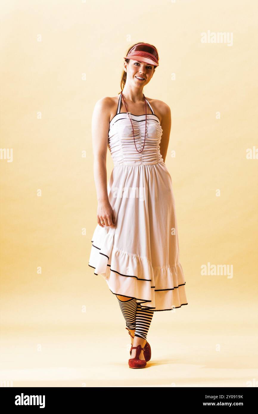 Woman with red peaked cap and white dress Stock Photo - Alamy