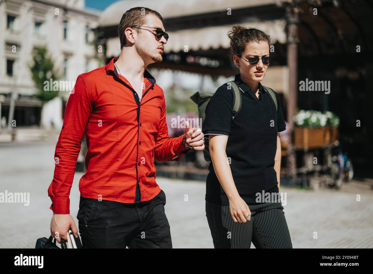 Two business professionals walking and discussing work in an urban ...