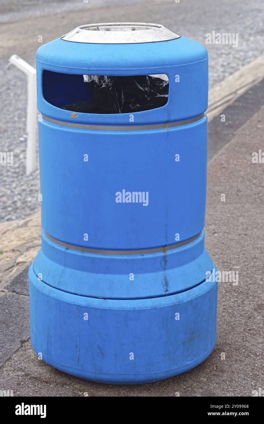 Blue plastic trash bin at street Stock Photo - Alamy