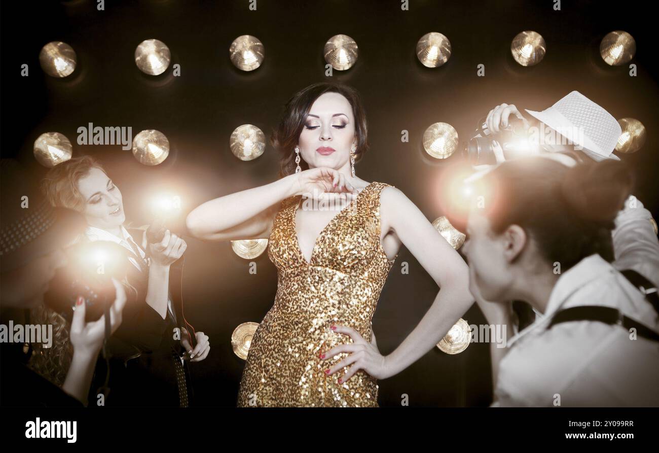 Superstar woman wearing golden shining dress posing to paparazzi Stock ...