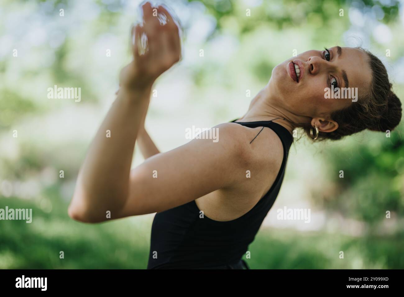Lovely girl dancing in nature, female dancer performing modern dance in a green forest setting ...