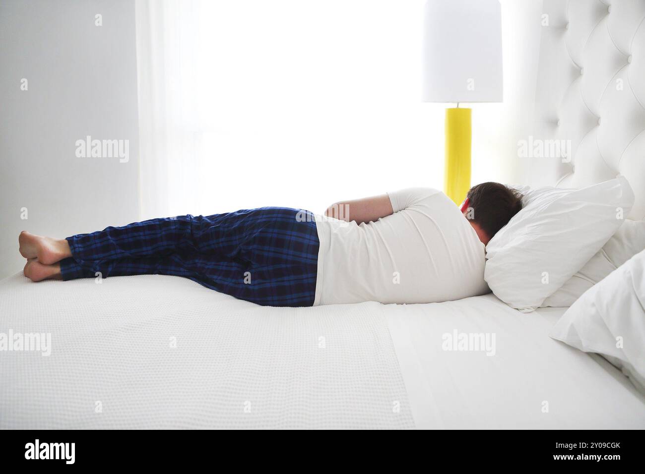 Young man sleeping in the bed room. back view Stock Photo - Alamy