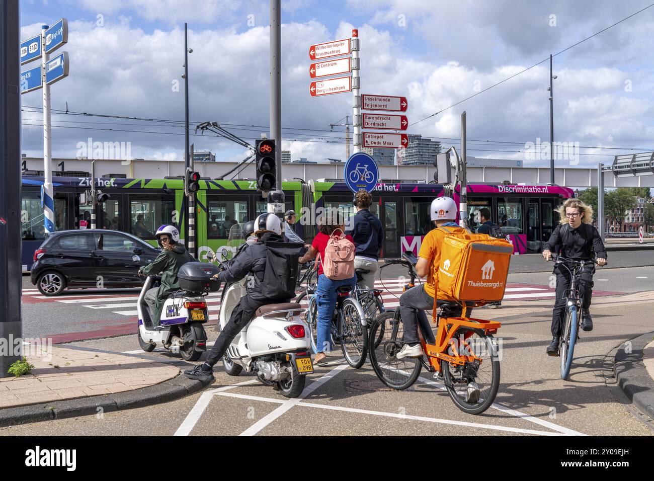 Cyclist, moped rider, waiting at a red traffic light, Feijenoord, in ...