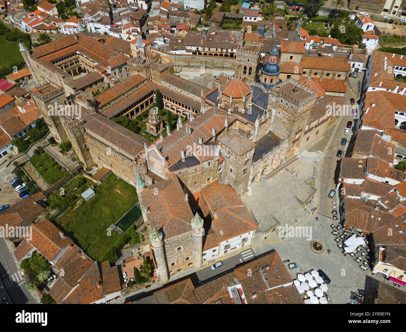 Aerial view of an old monastery with red roofs and village square ...