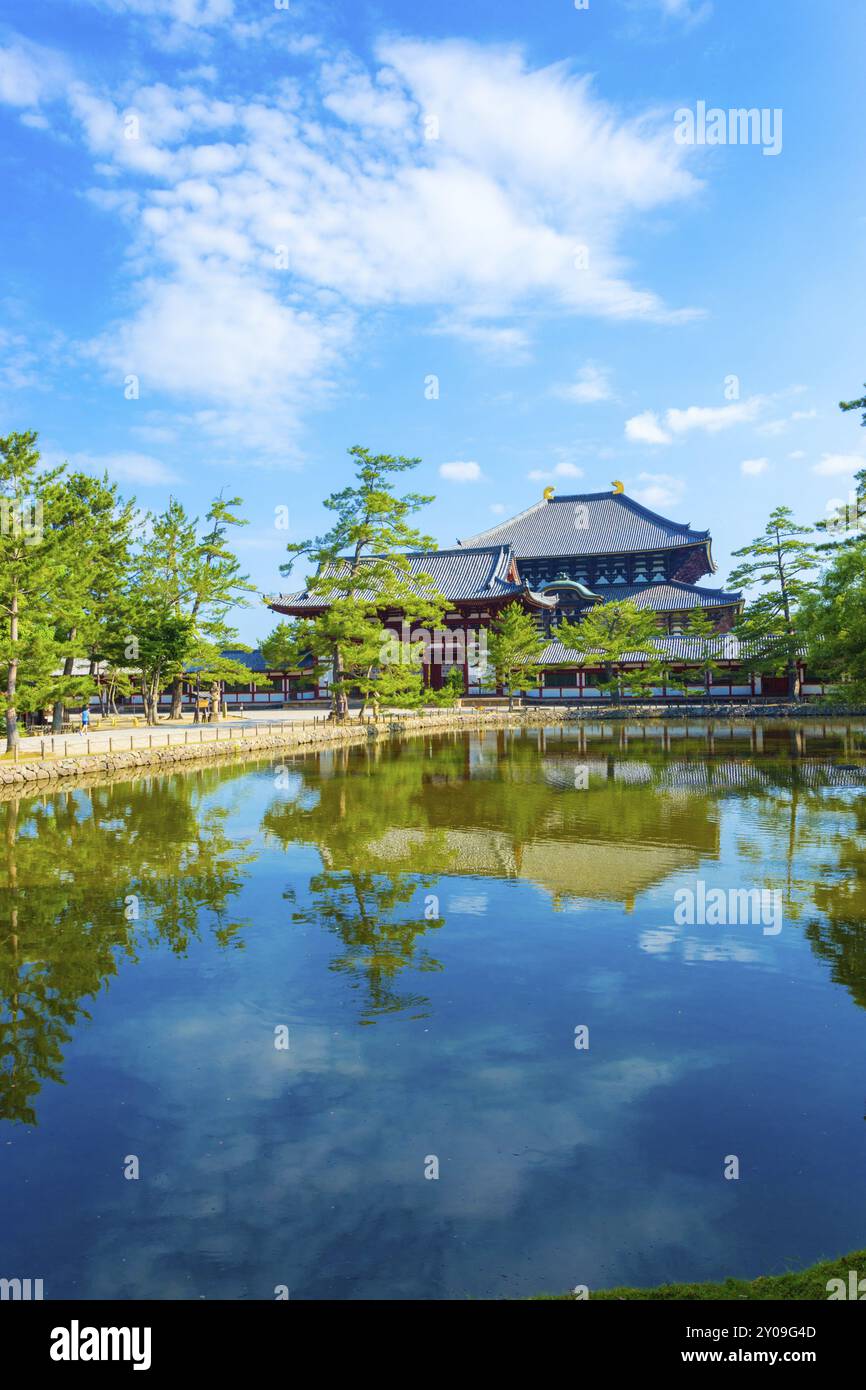Pedestrian walkway and calm pond reflectiion of front red entry gate to ...