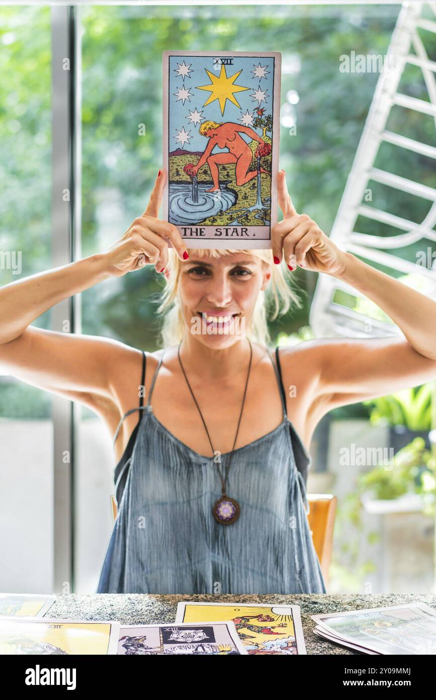 Smiling tarot reader proudly displaying the giant Tarot card The Star ...