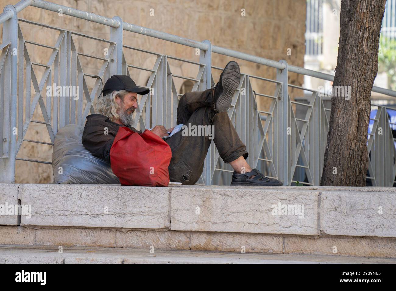 Jerusalem, Israel - July 2nd, 2024: A street dwelling man and his few ...