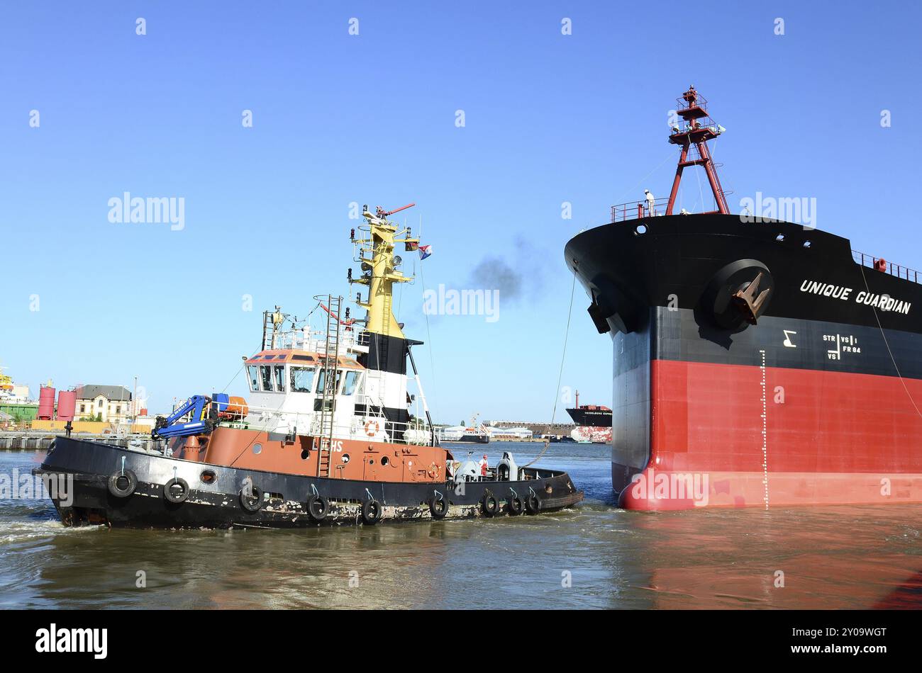 The oil tanker Unique Guaridan is towed in the harbour basin by a ...