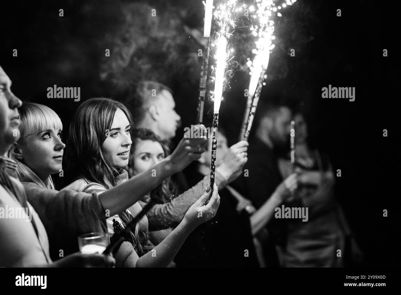 cold fire from cake candles and fireworks in the hands of people around ...