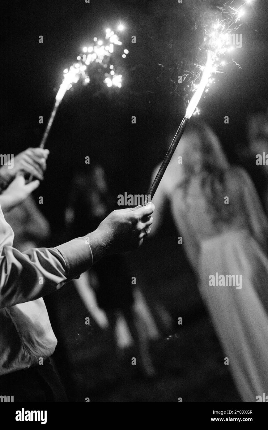cold fire from cake candles and fireworks in the hands of people around ...