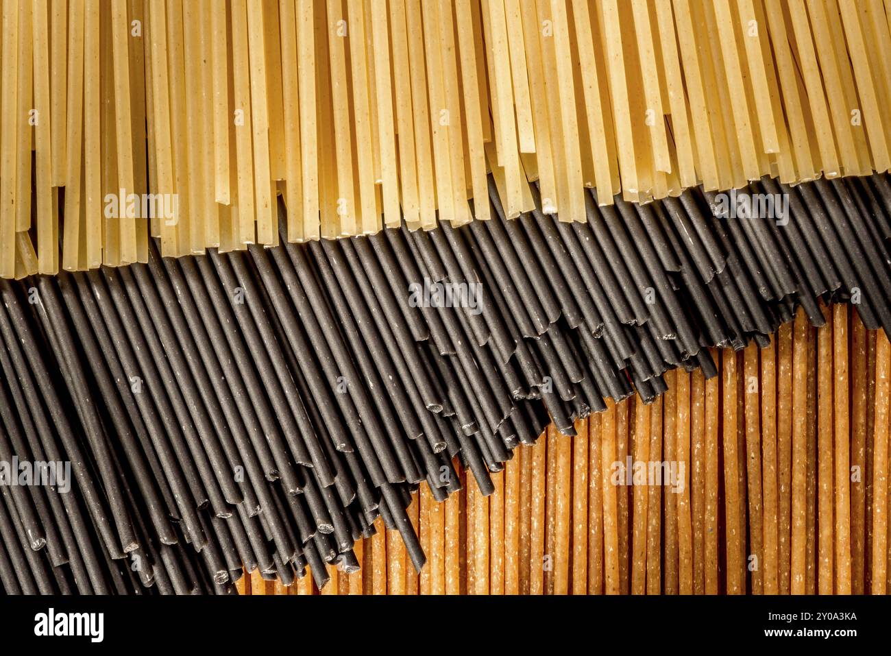 Three layers of three different colours of raw spaghetti ly spread, one ...