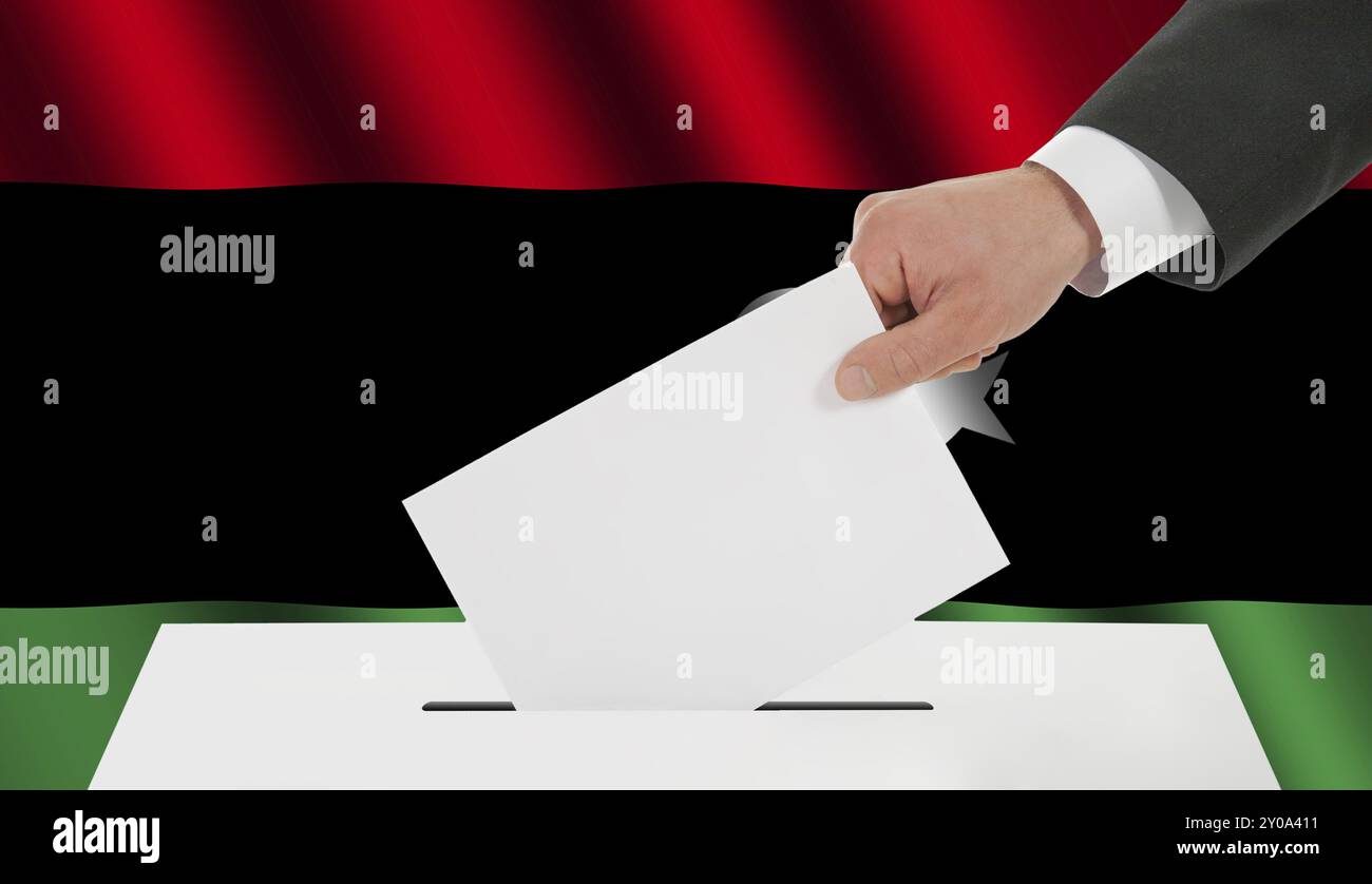 The Libyan flag and the hand with the bulletin about the ballot box ...