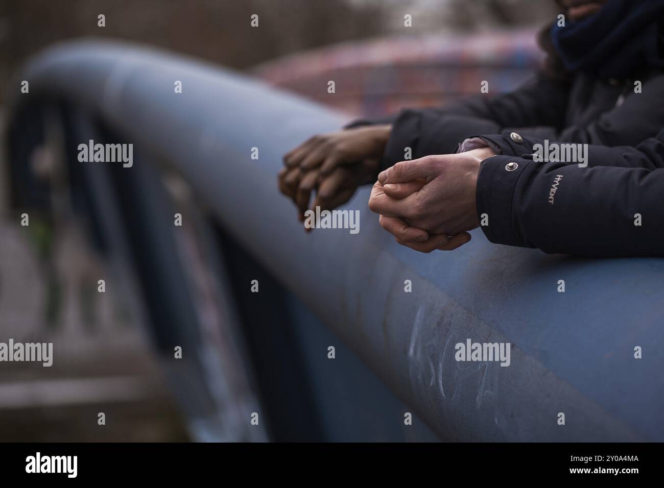 Two people place their hands relaxed on a railing Stock Photo - Alamy