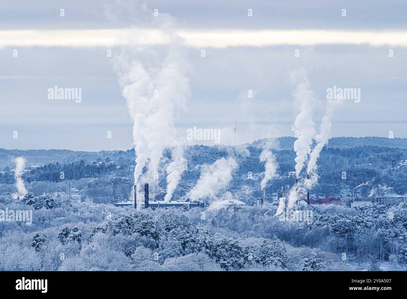 Steam rising from industry behind a forest Stock Photo - Alamy