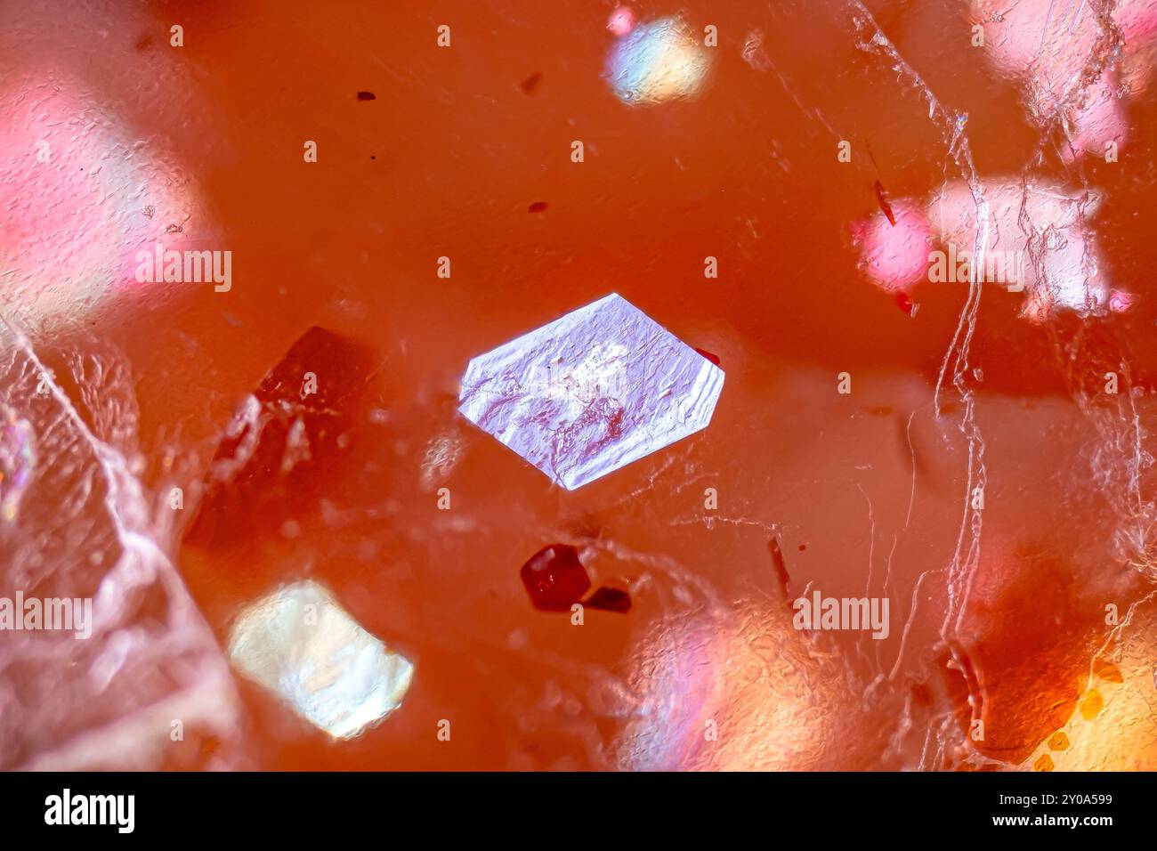 colorful hematite inclusion in sunstone. Micro photography extreme ...