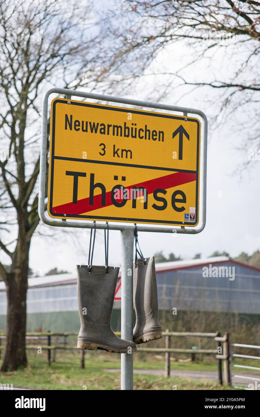 Rubber boots installed on a town exit sign Stock Photo - Alamy