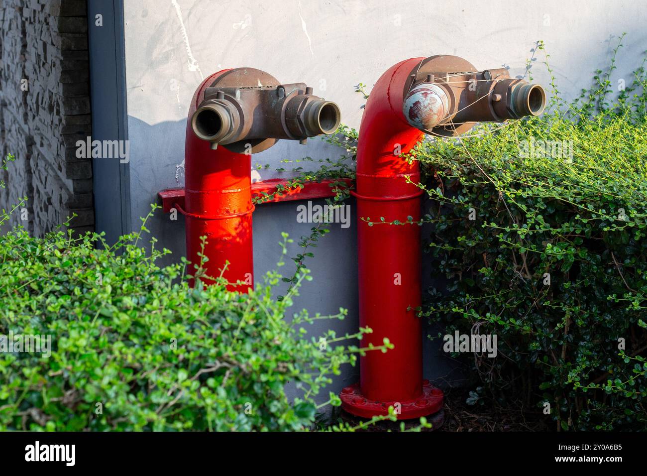 Red fire hydrant near a residential building. A device connected to the ...