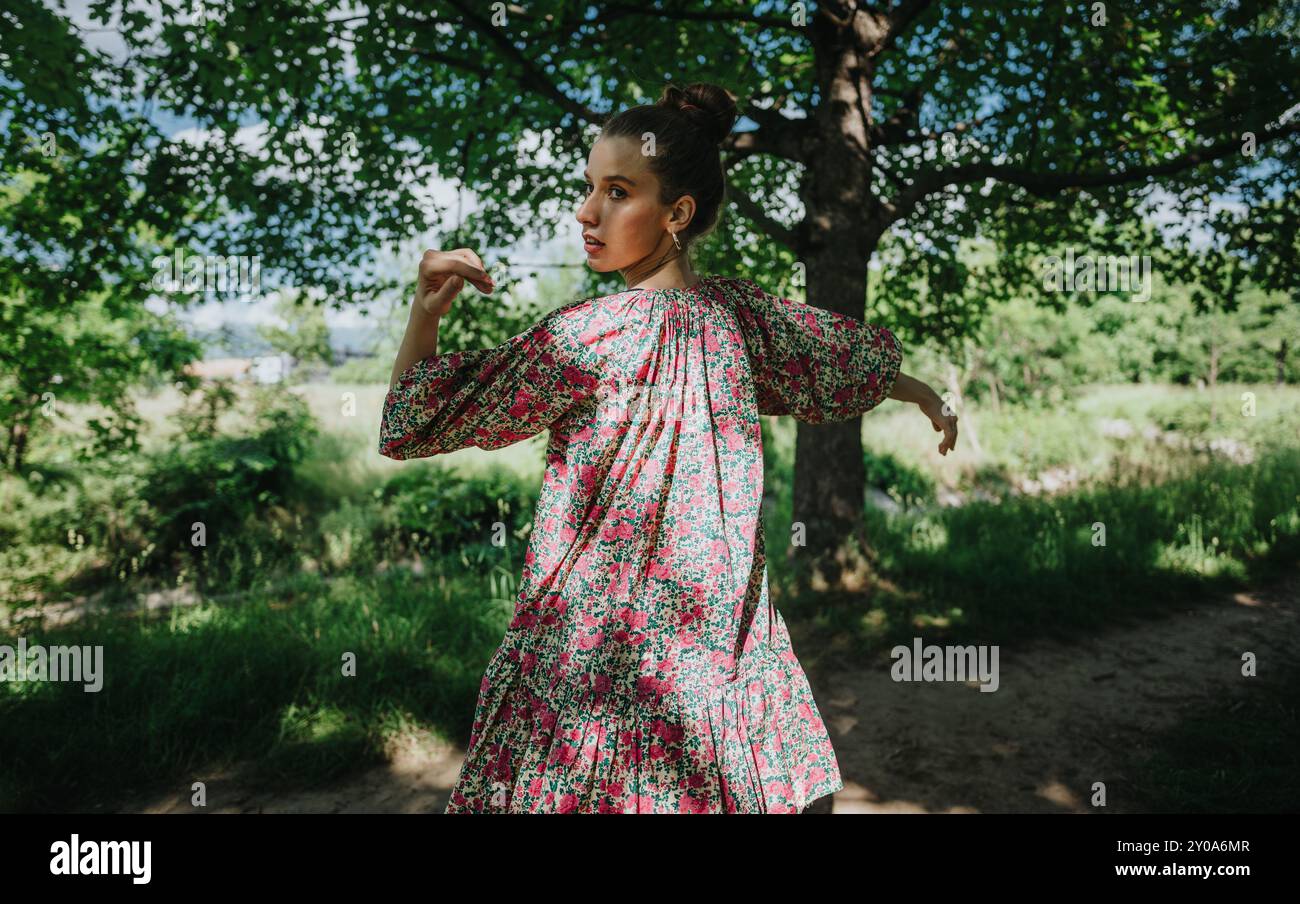 Girl performing modern dance in nature under a tree with bright ...