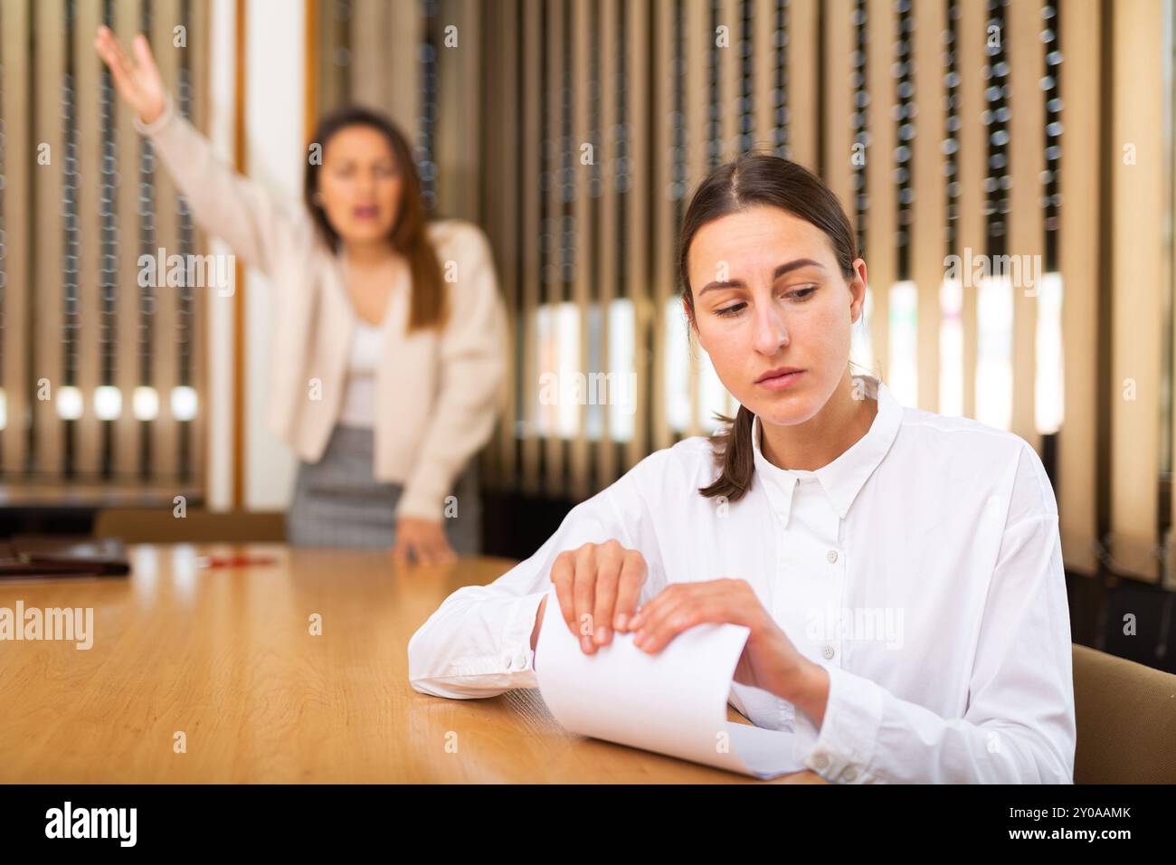 Unhappy female office employee after reprimand from angry chief Stock ...
