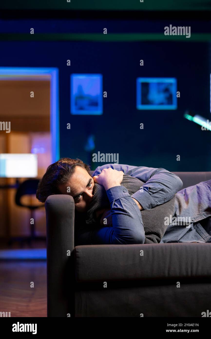 Sad man lounged on couch feeling heartbroken while watching tragic ...