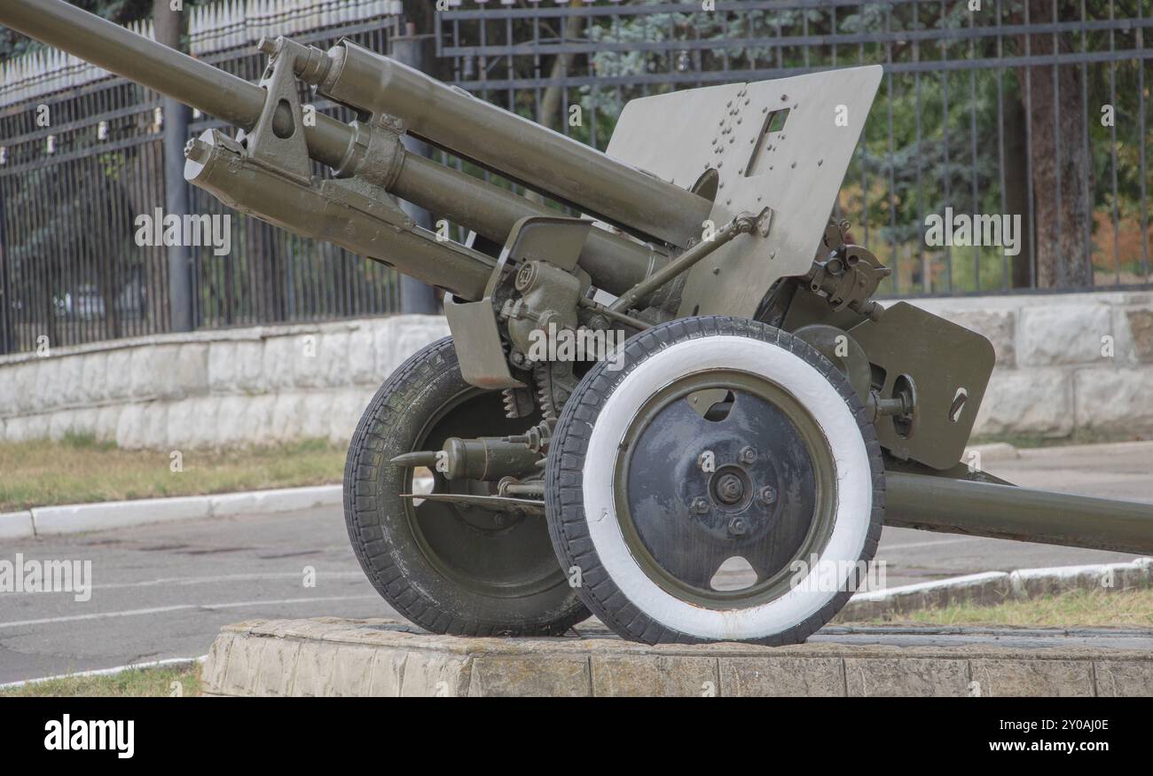 Old Soviet anti-aircraft gun with white wheels on the street in a post ...