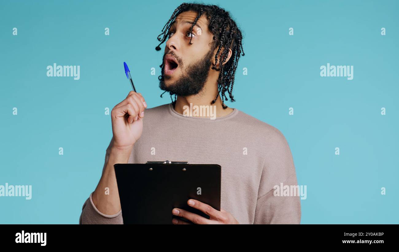 Creative man brainstorming ideas, writing on document using pen. BIPOC ...