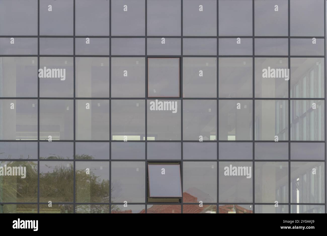 A frontal view of the exterior wall of an office building with large ...