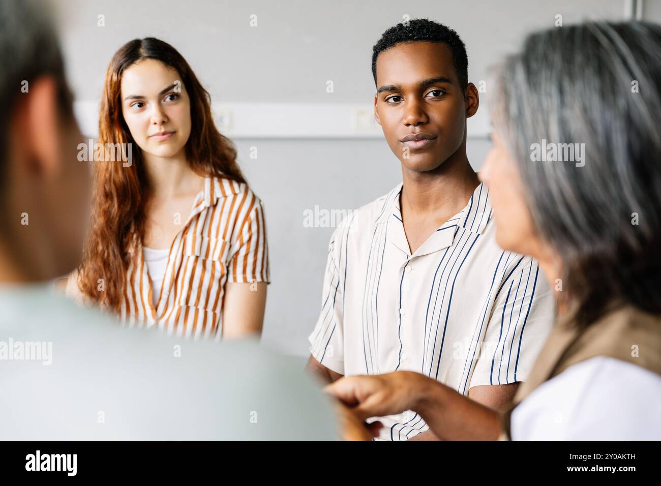 Young group of teenage high school students discussing in classroom ...