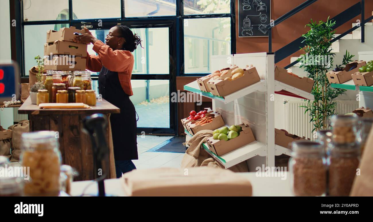 Storekeeper arranging crates of fruits and veggies on shelves ...