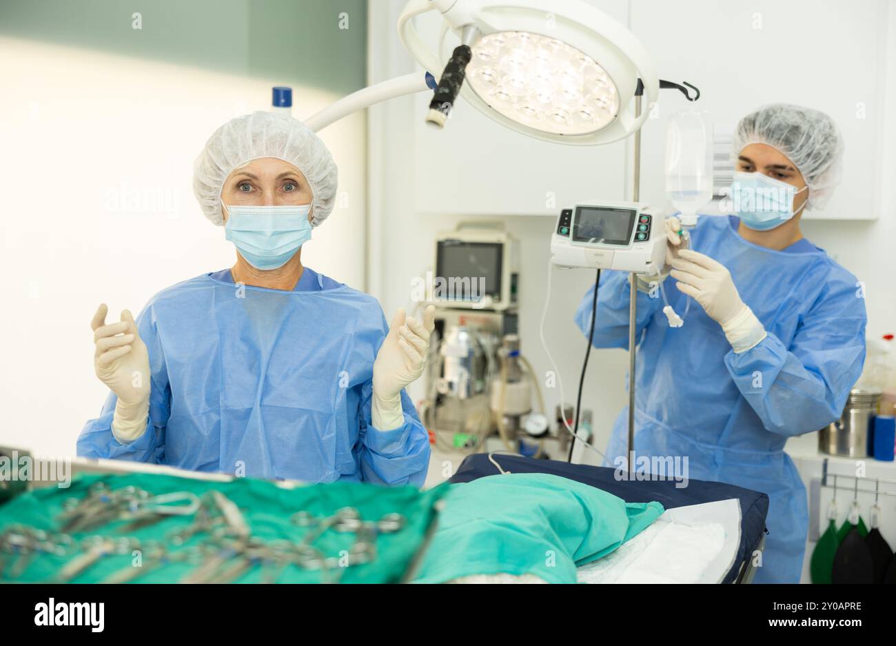Elderly female veterinarian in surgical outfit standing in veterinary ...