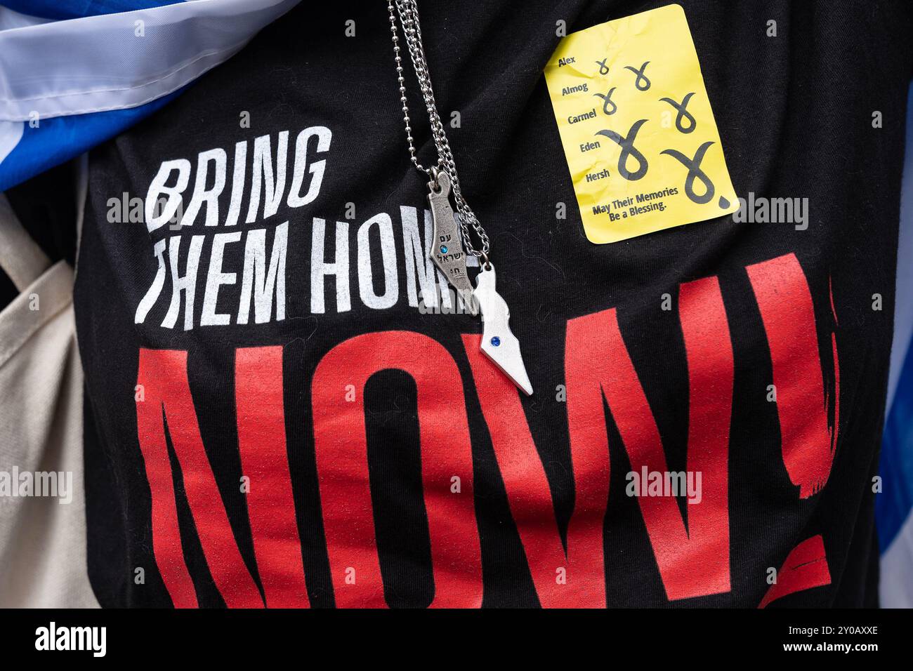 Activist wears sticker with names of killed hostages during memorial ...