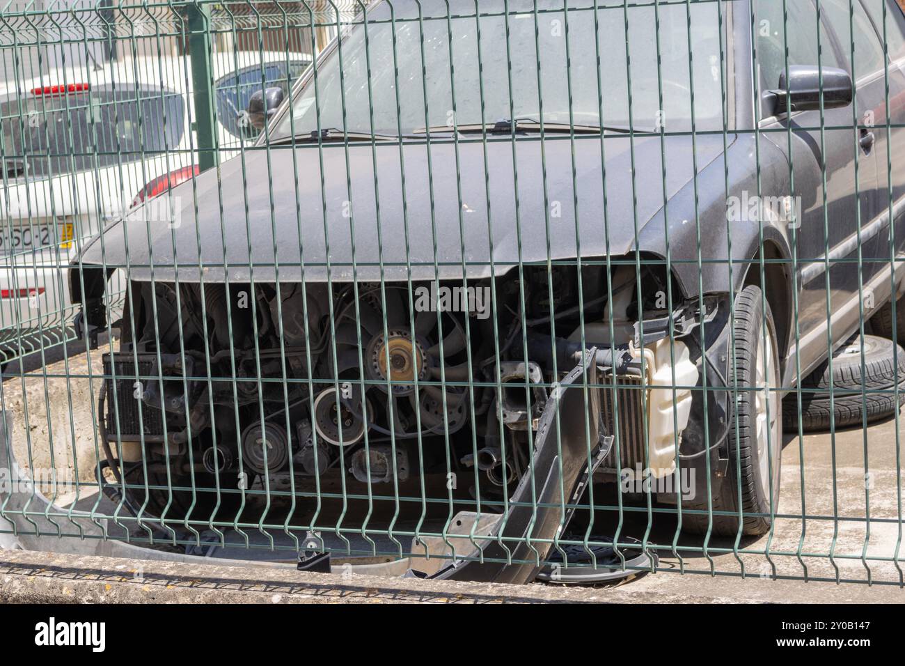 Damaged car missing its front bumper and hood is seen parked behind a ...