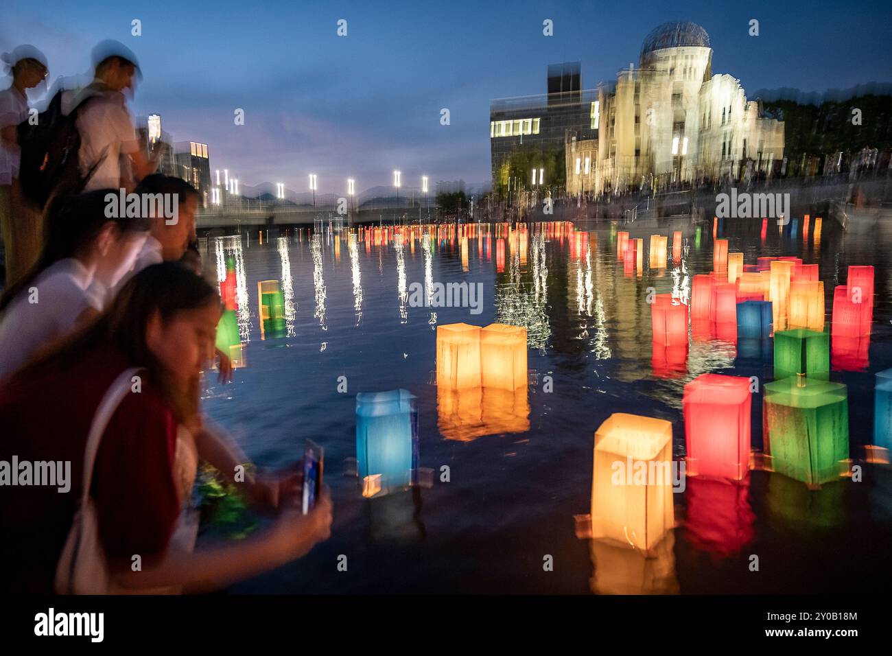 People float lanterns on the river, in front of Atomic Bomb Dome with ...