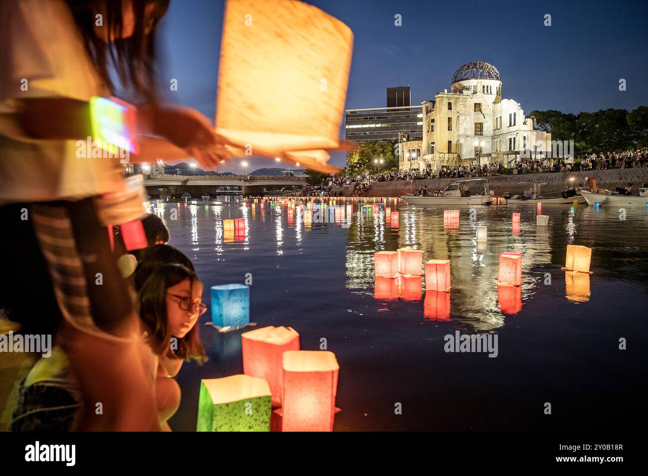 People float lanterns on the river, in front of Atomic Bomb Dome with floating lamps on Motoyasu ...