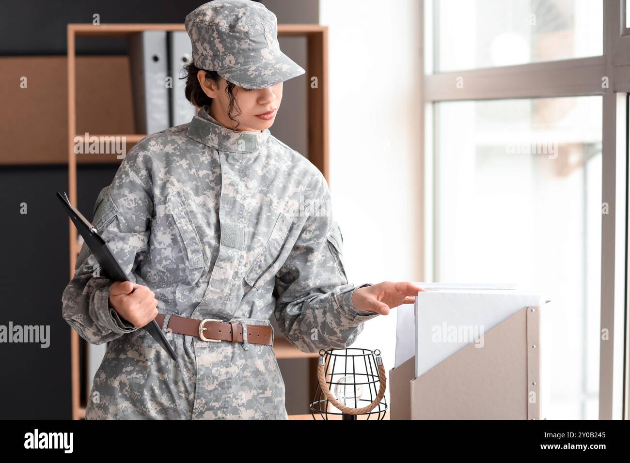 Female African-American soldier with clipboard working at headquarters ...