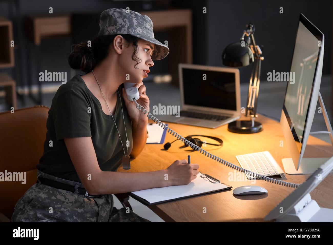 Female African-American soldier talking by telephone in headquarters at ...