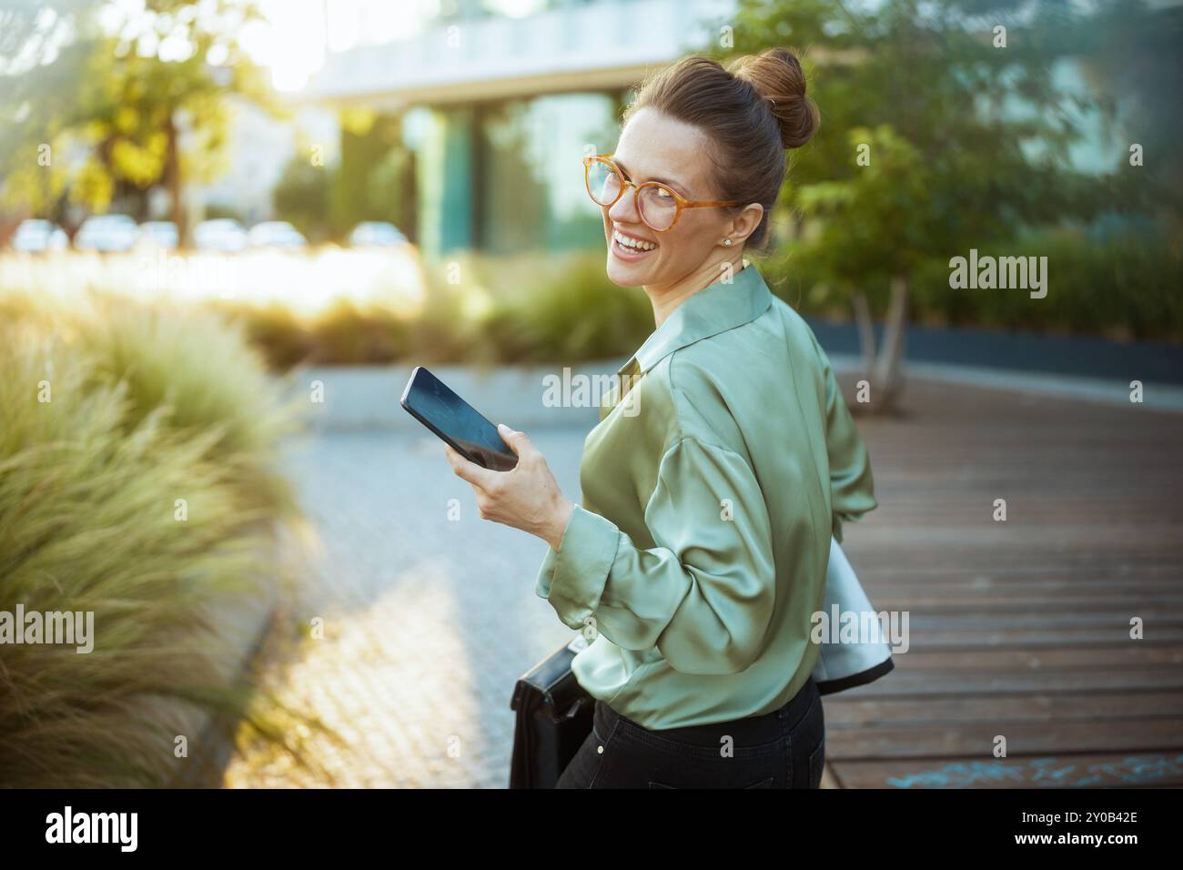 happy modern 40 years old woman employee near office building in green ...