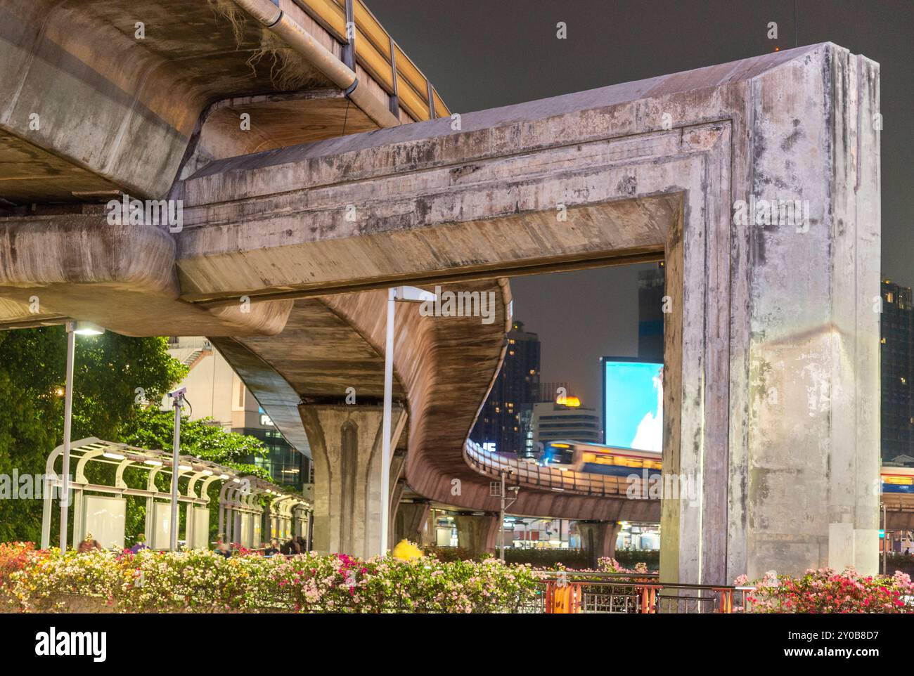 At night an overhead passenger train approaches,running over huge ...