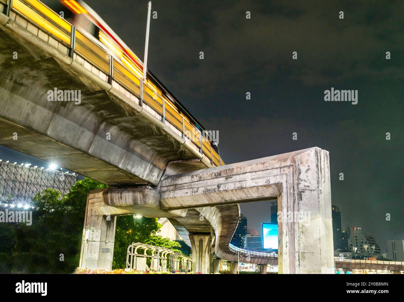 At night an overhead passenger train approaches,running over huge ...