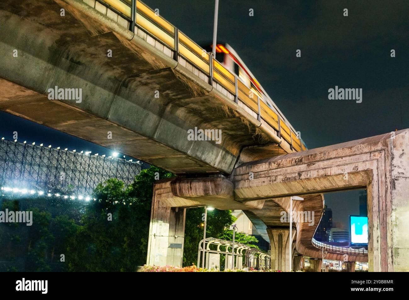 At night an overhead passenger train approaches,running over huge ...