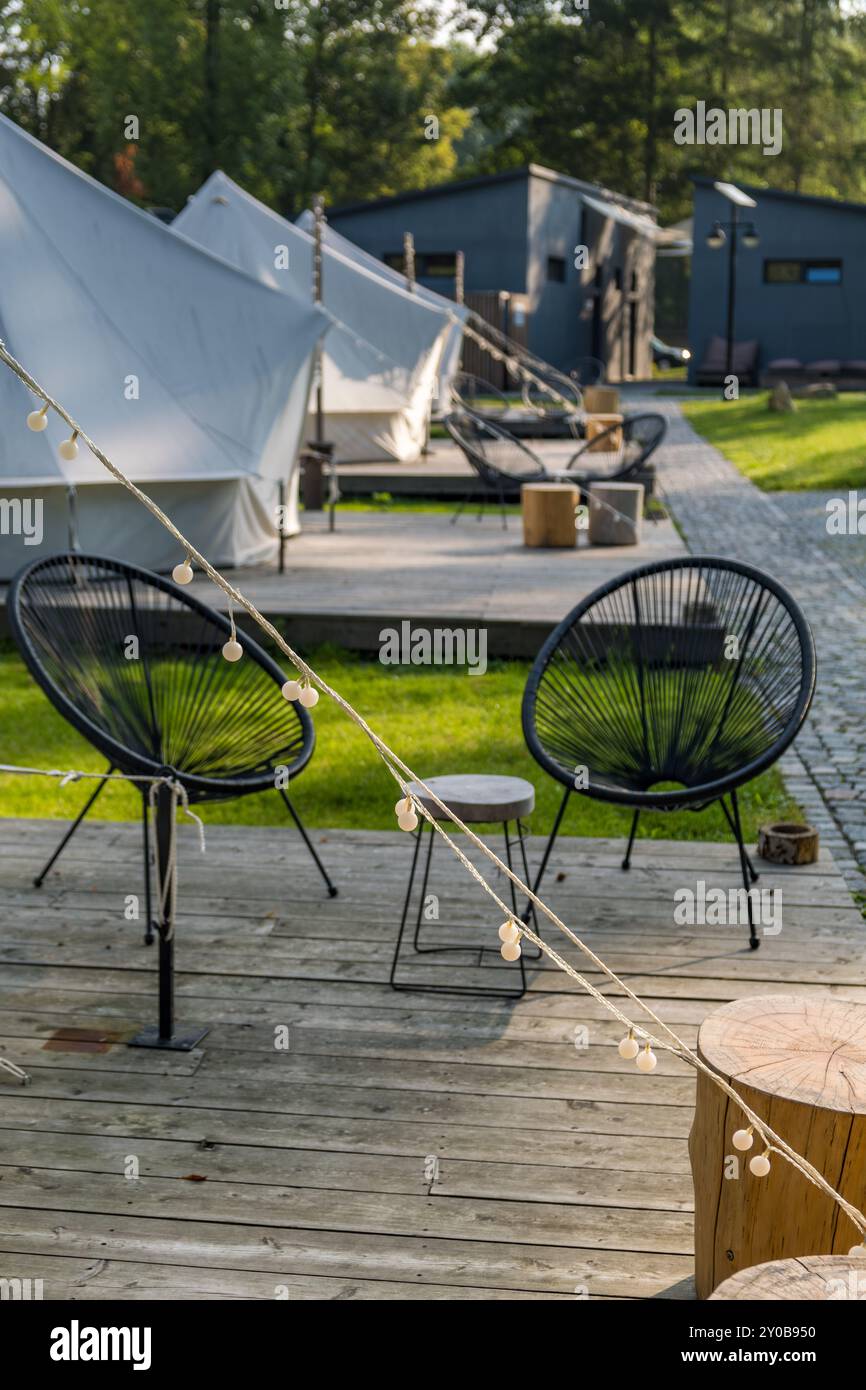 Luxury camping tents on wooden platforms surrounded by lush greenery ...