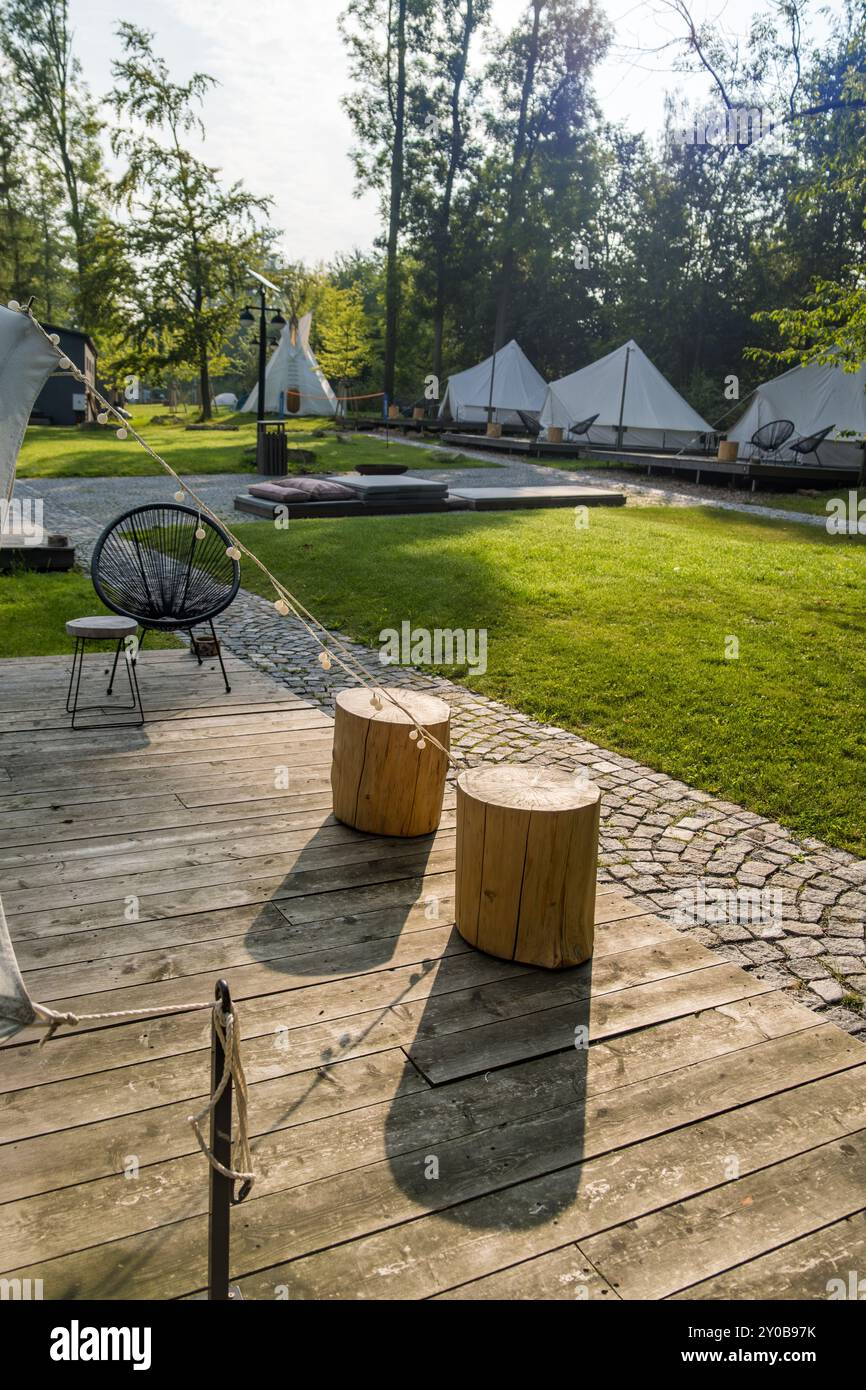 Luxury camping tents on wooden platforms surrounded by lush greenery ...
