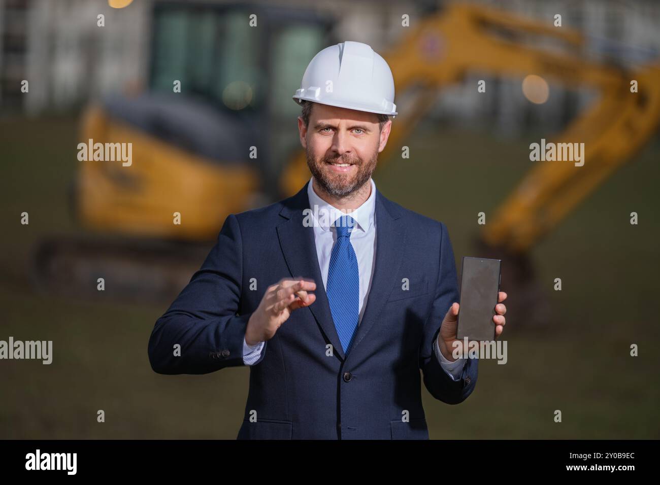 Construction owner near excavator. Confident construction owner in ...