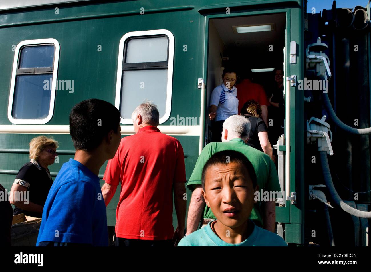 Passengers on the Trans Mongolian train strreach their legs in a small ...
