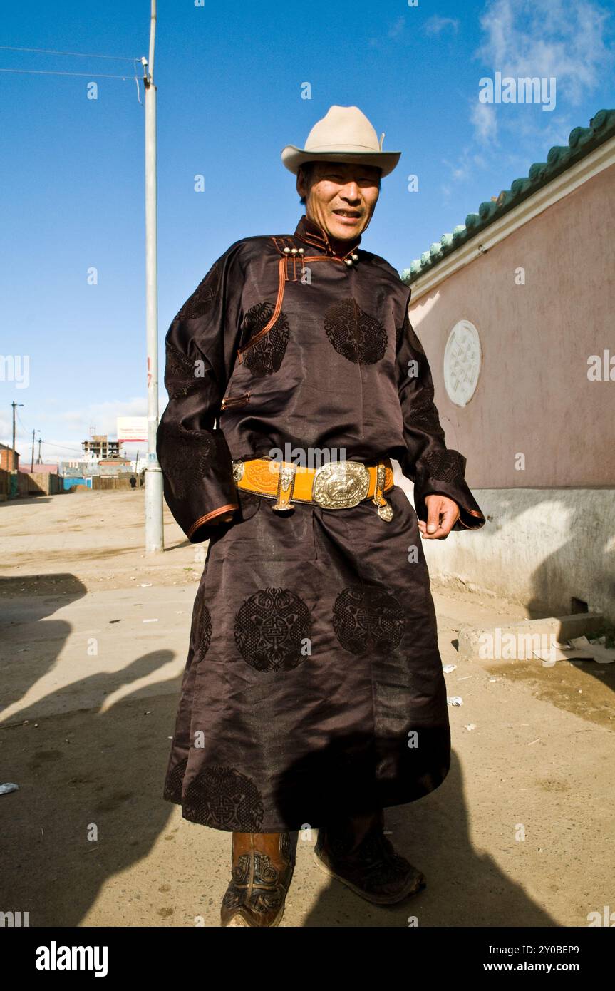 A Mongolian man dressed in a traditional Del and a colorful belt. Photo ...
