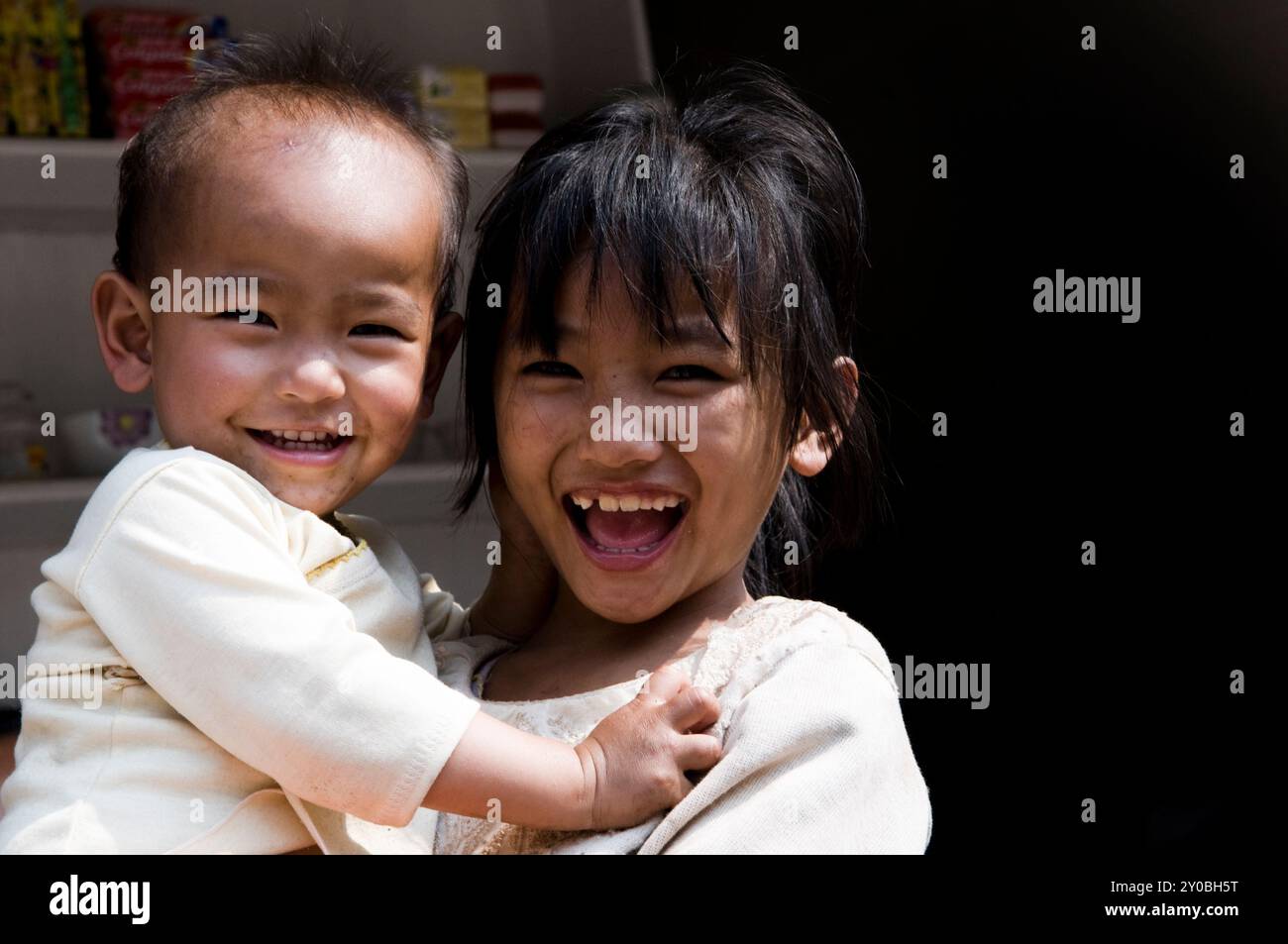A girl holding her younger brother. Yunnan province, China Stock Photo ...